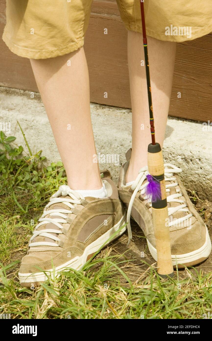 Low section view of a man holding a fishing rod Stock Photo - Alamy