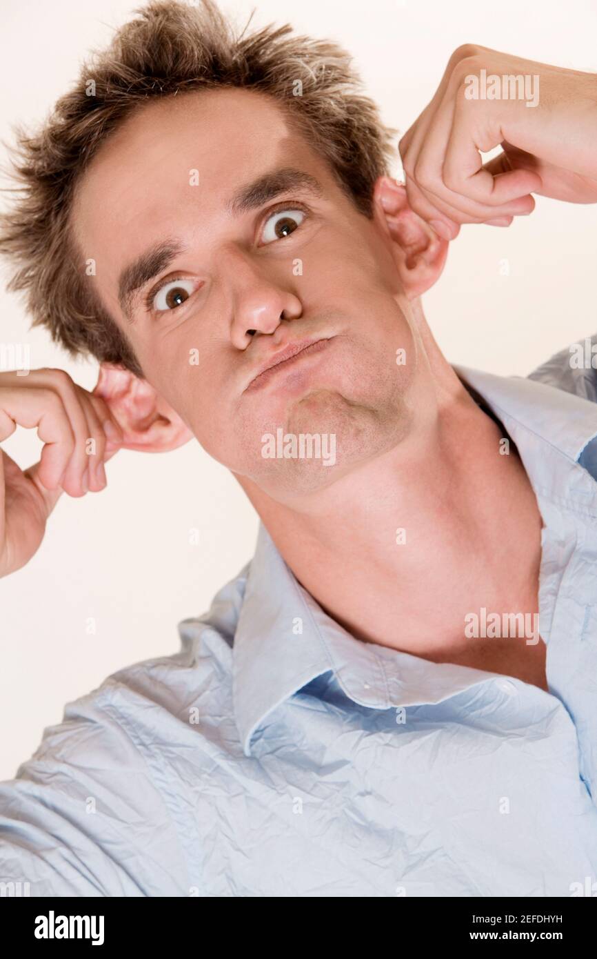 Close-up of a young man pulling his ears Stock Photo - Alamy