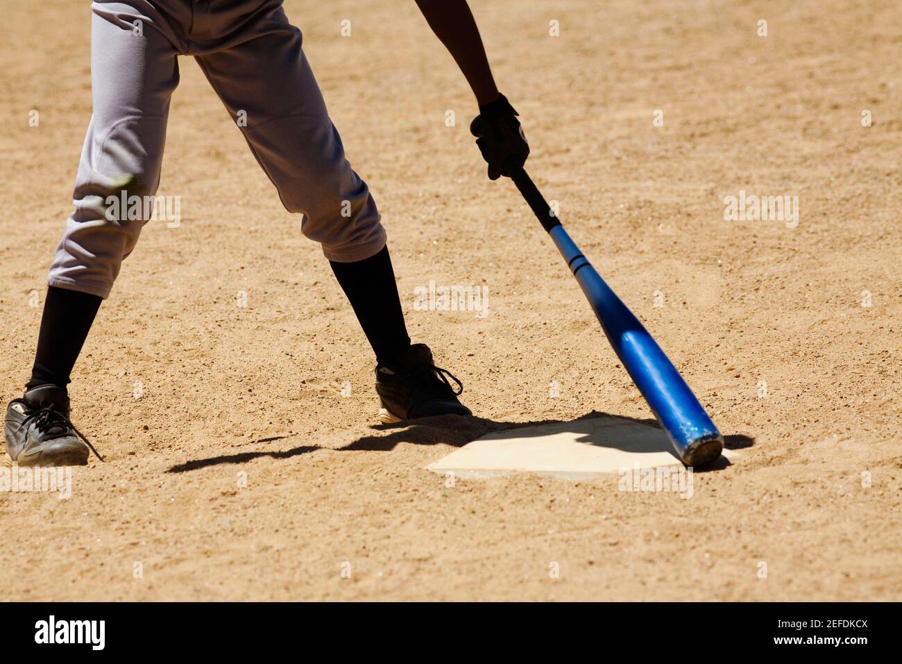 Low section view of a man holding a baseball bat Stock Photo - Alamy