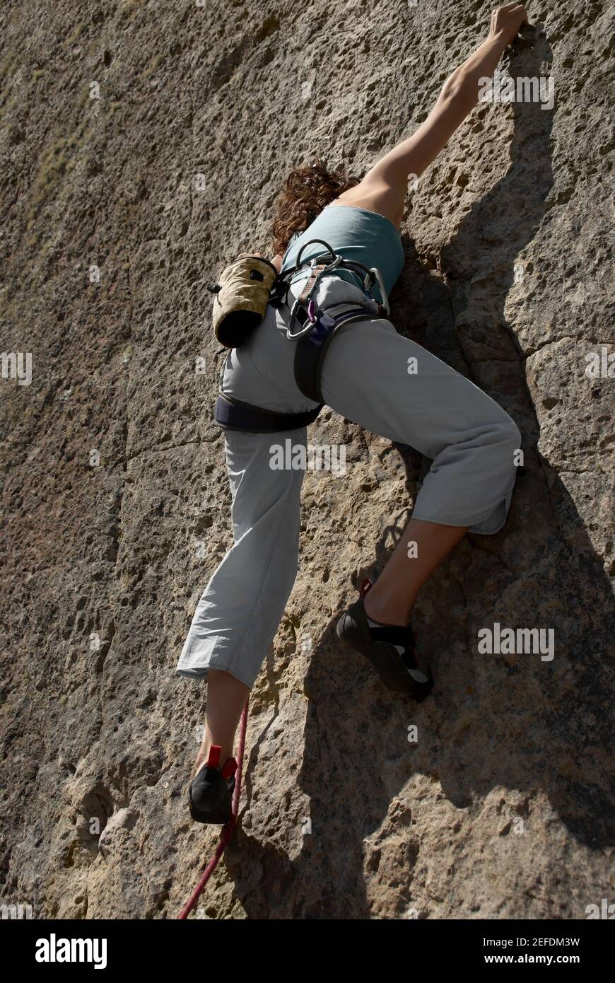 Low angle view of a female rock climber scaling a rock face Stock Photo ...