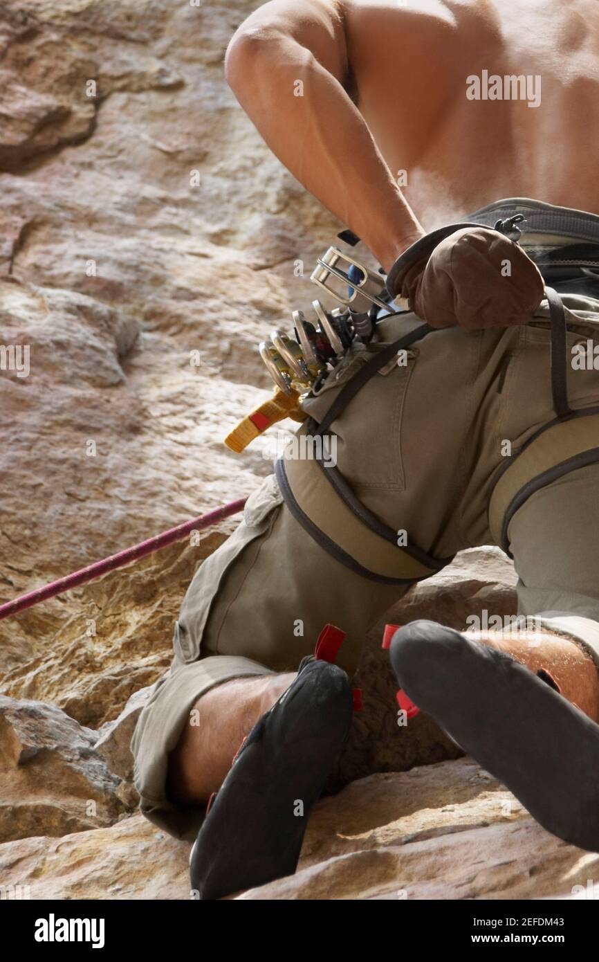 Low angle view of a male rock climber climbing a rock Stock Photo - Alamy