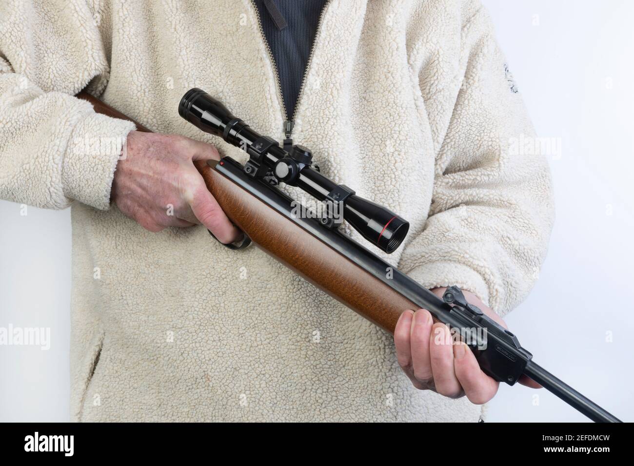 A man holding an air rifle with a telescopic sight Stock Photo - Alamy