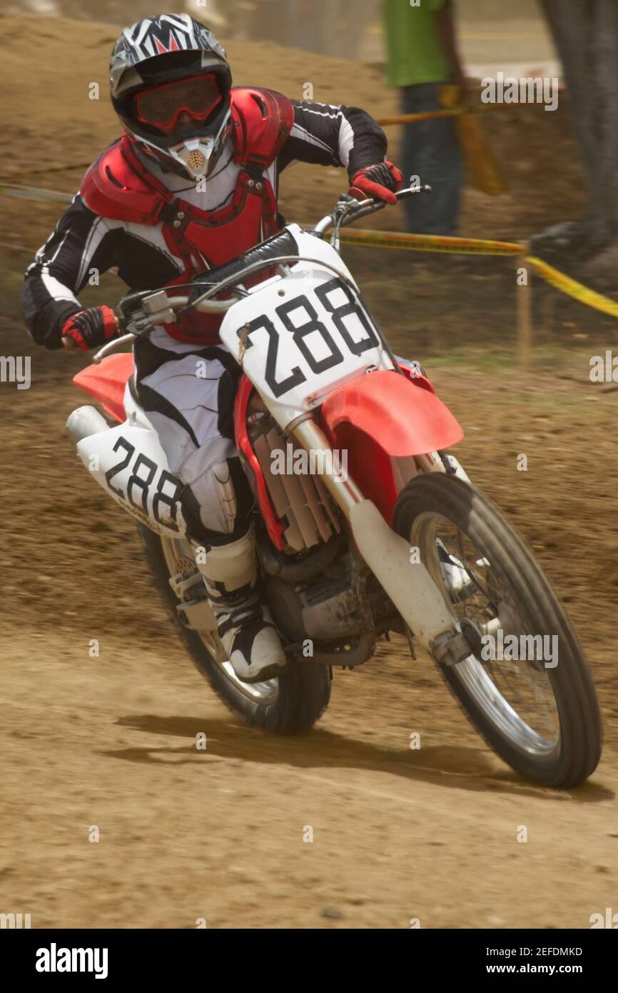 Motocross rider riding a motorcycle and leaning into a turn Stock Photo ...