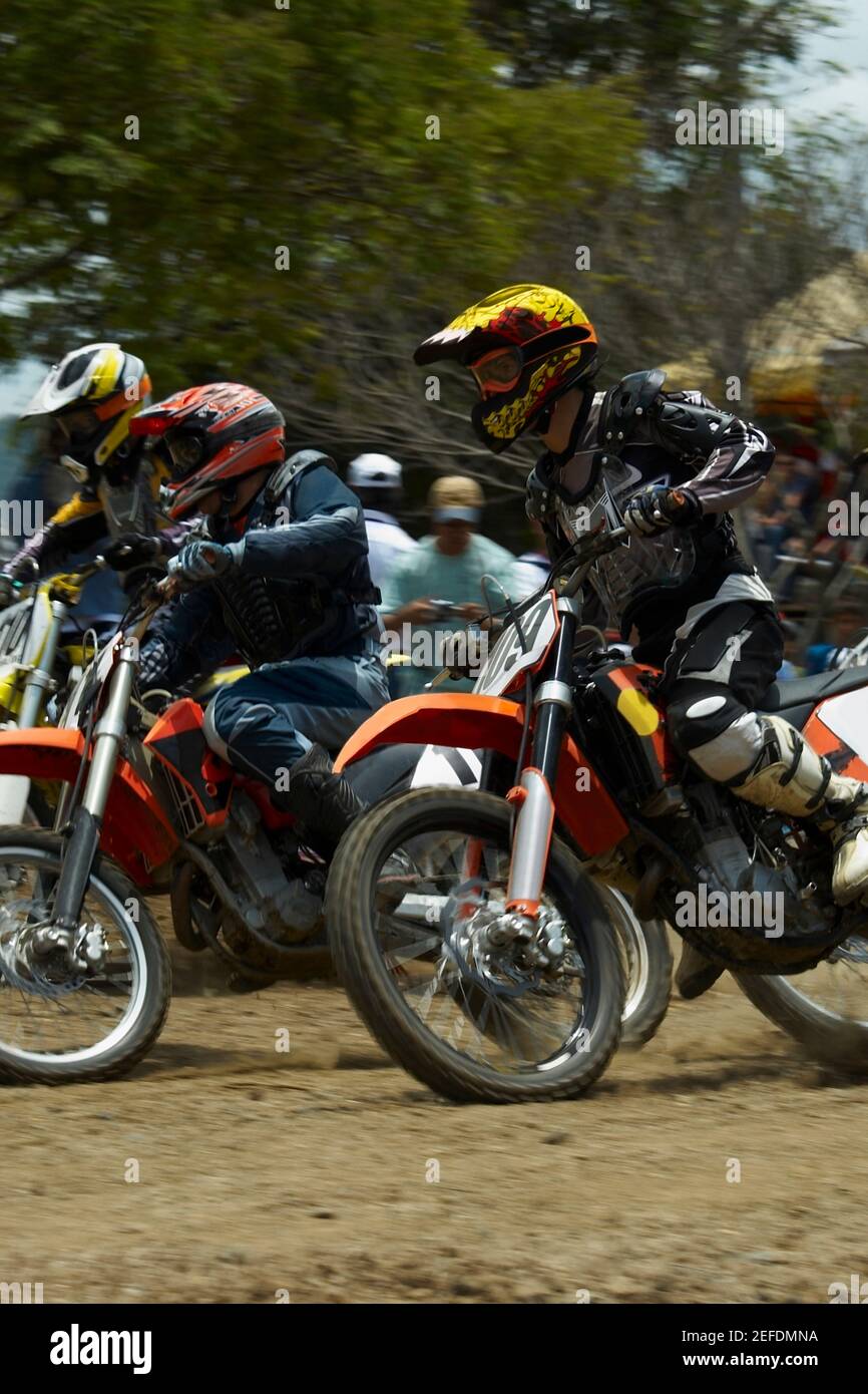 Side profile of three motocross riders riding motorcycles Stock Photo ...