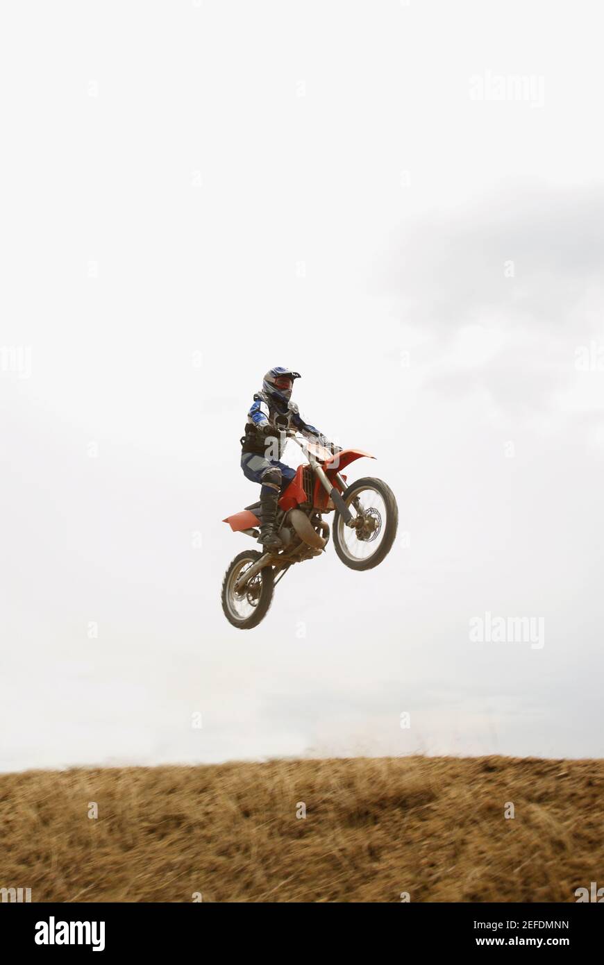 Low angle view of a motocross rider performing a jump on a motorcycle ...