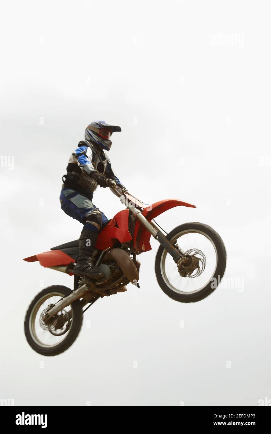 Low angle view of a motocross rider performing a jump on a motorcycle ...