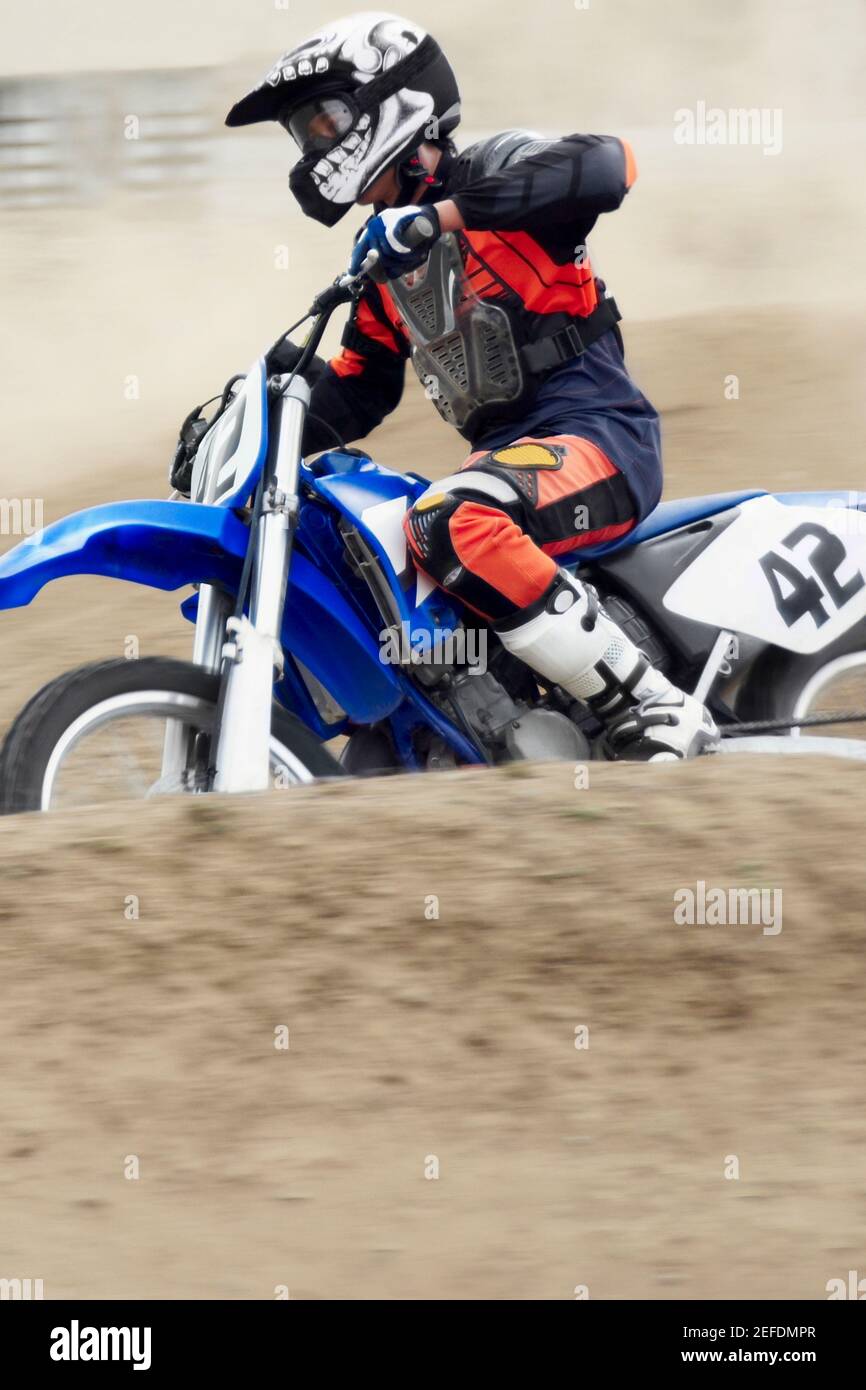 Side profile of a motocross rider riding a motorcycle Stock Photo - Alamy