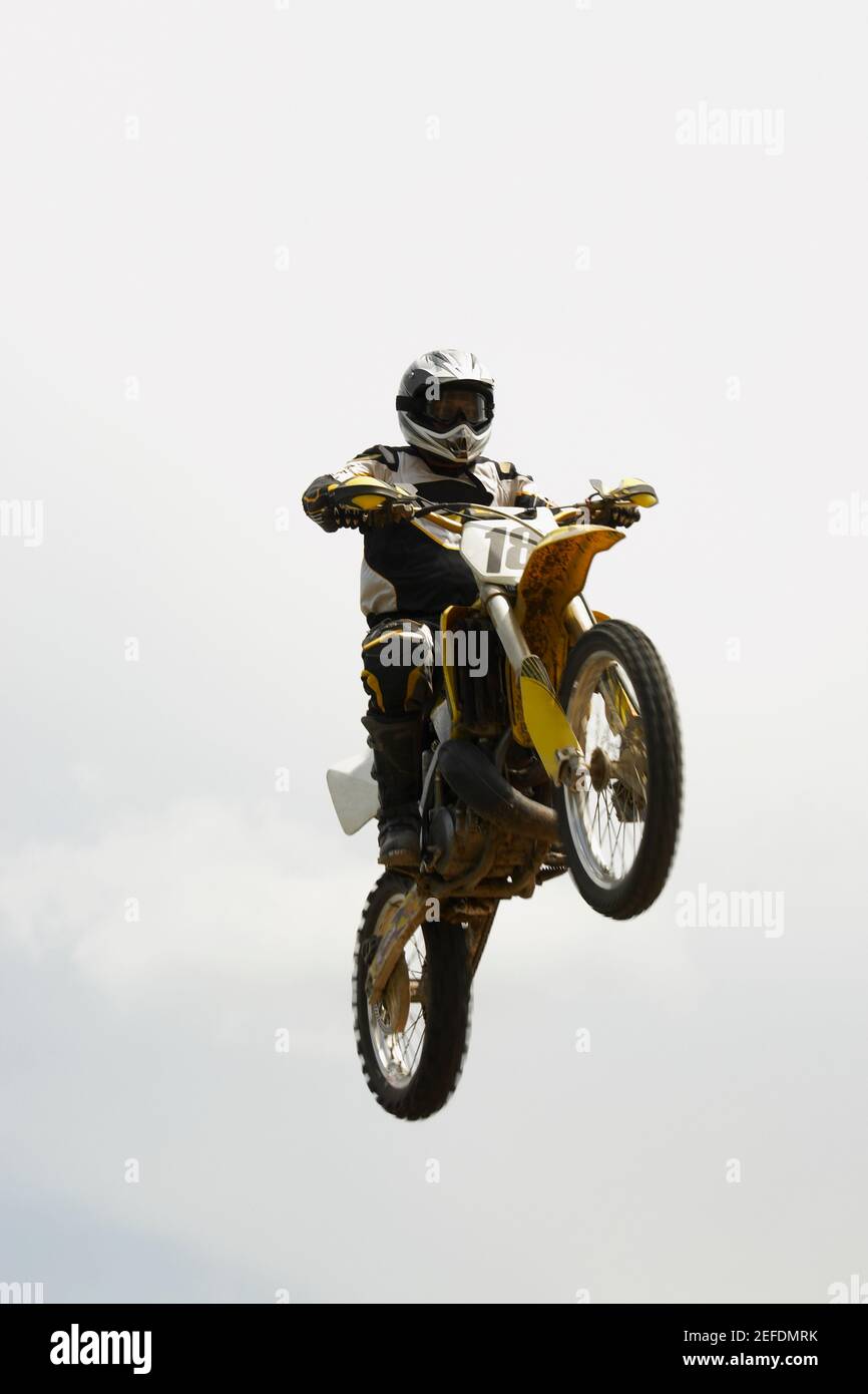 Low angle view of a motocross rider performing a jump on a motorcycle ...