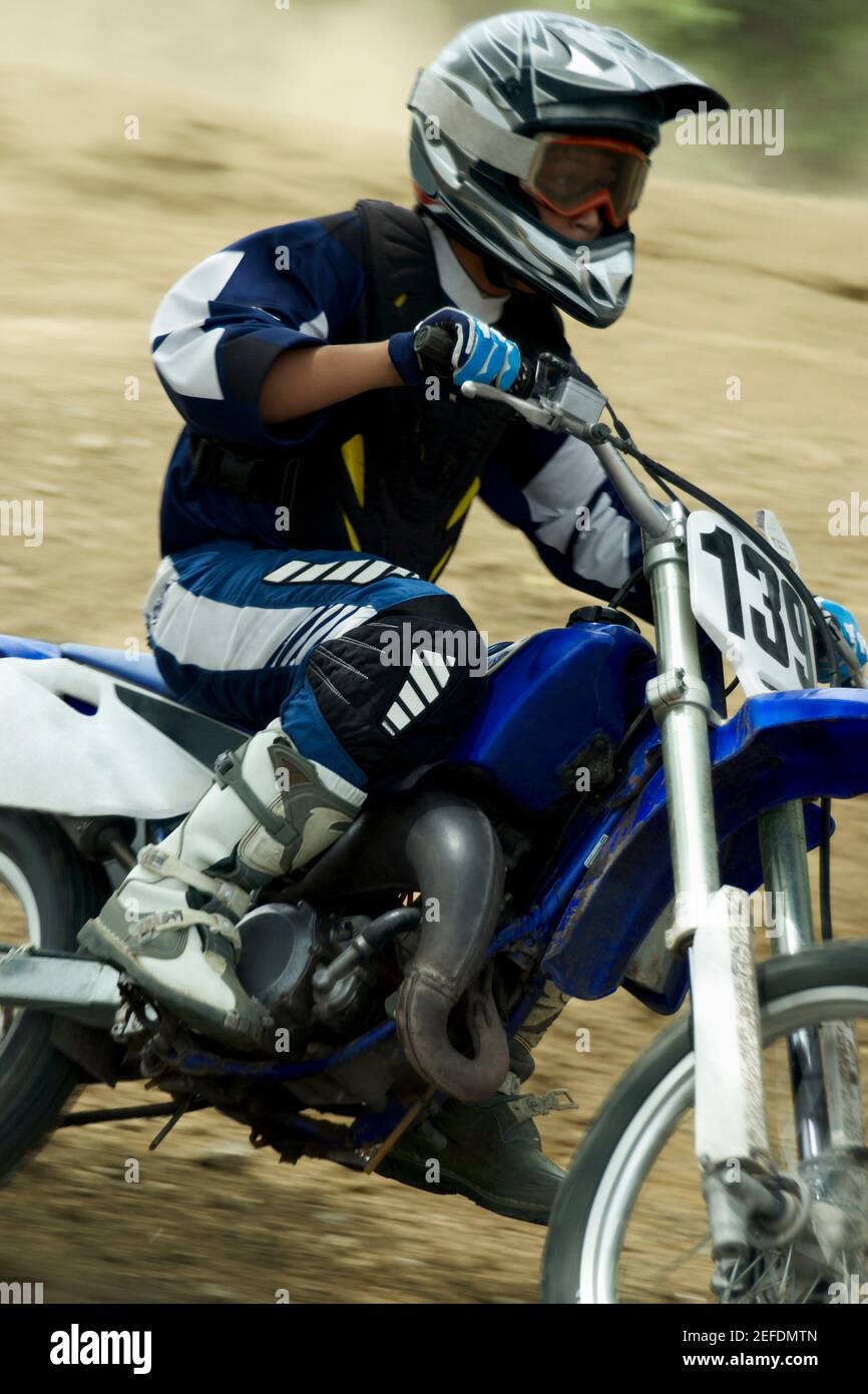 Side profile of a motocross rider riding a motorcycle Stock Photo - Alamy