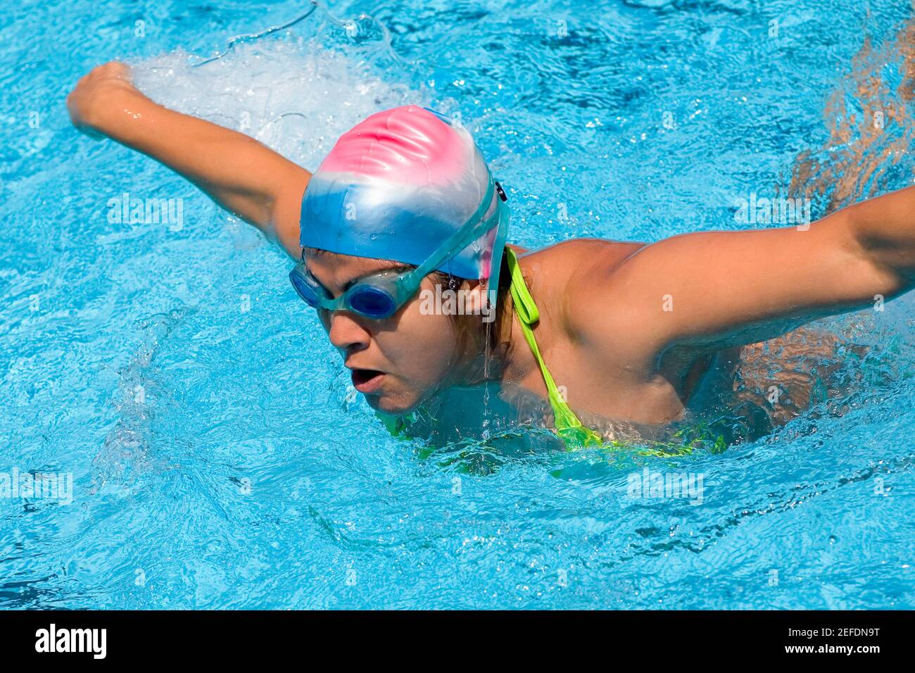 Young woman swimming the butterfly stroke in a swimming pool Stock ...