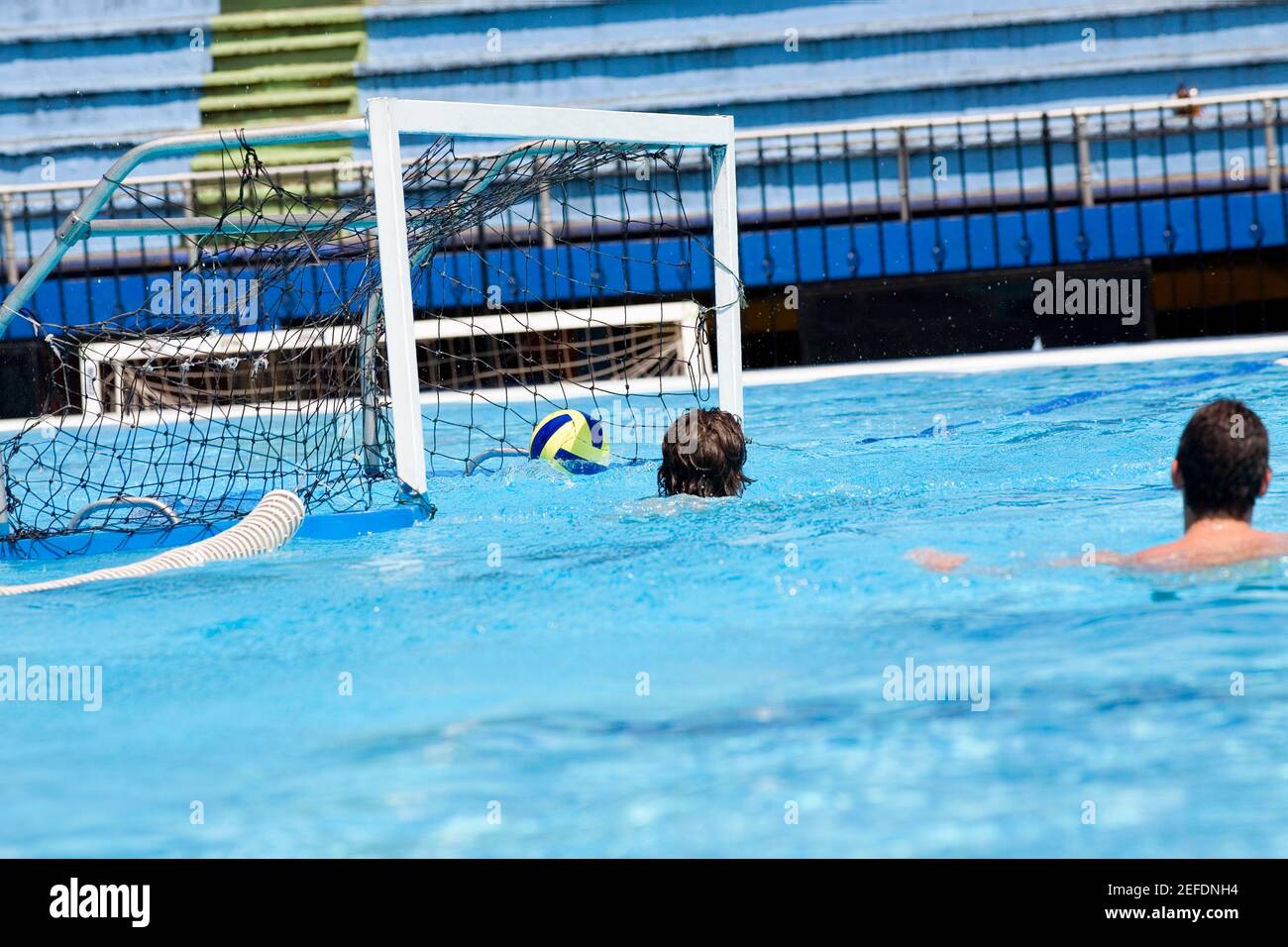 Two men playing water polo in a swimming pool Stock Photo - Alamy