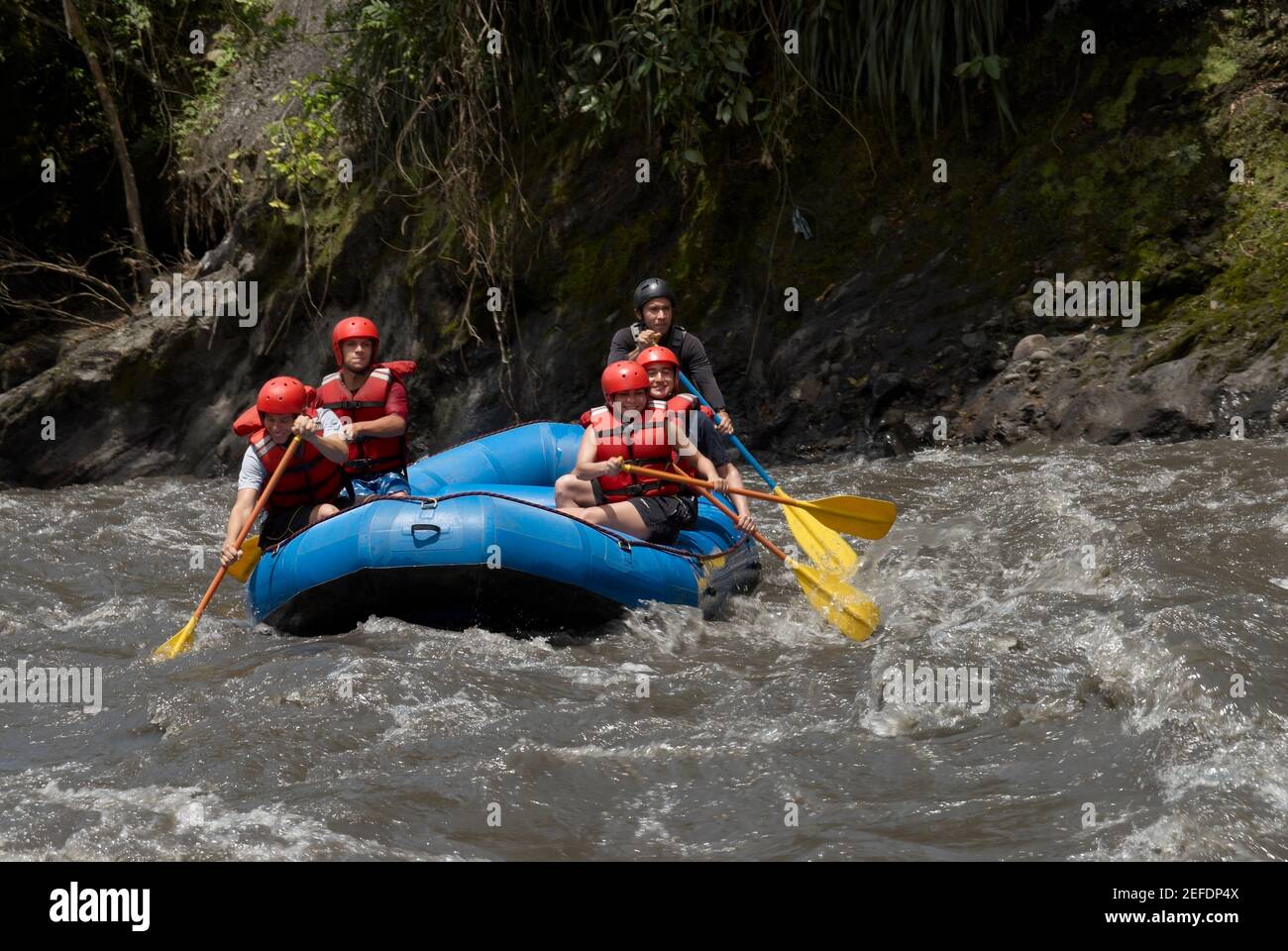 Five people rafting in a river Stock Photo - Alamy