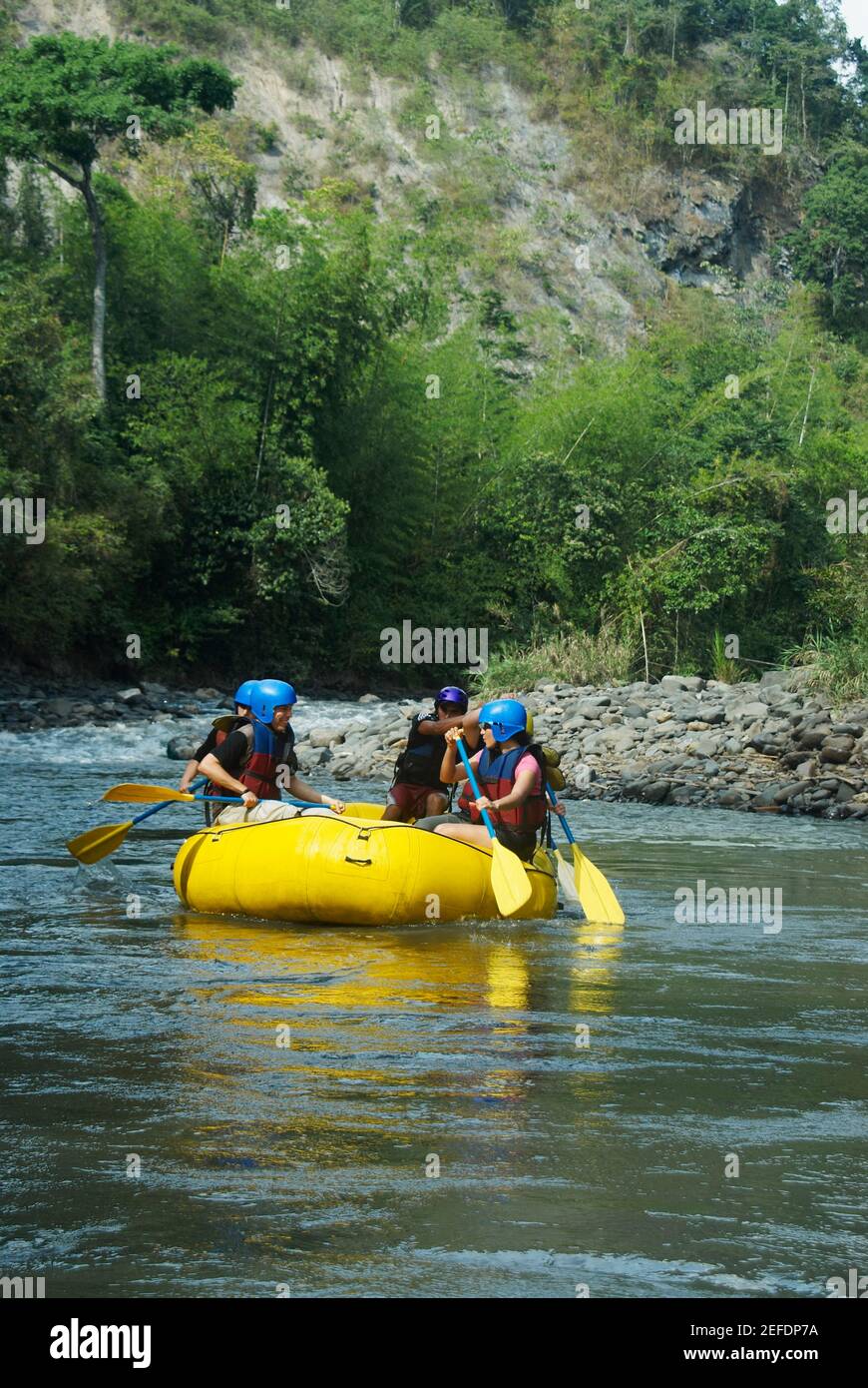 Four people rafting in a river Stock Photo - Alamy