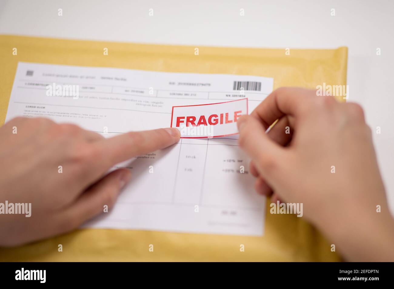 hands sticking fragile marks to parcel in envelope Stock Photo - Alamy