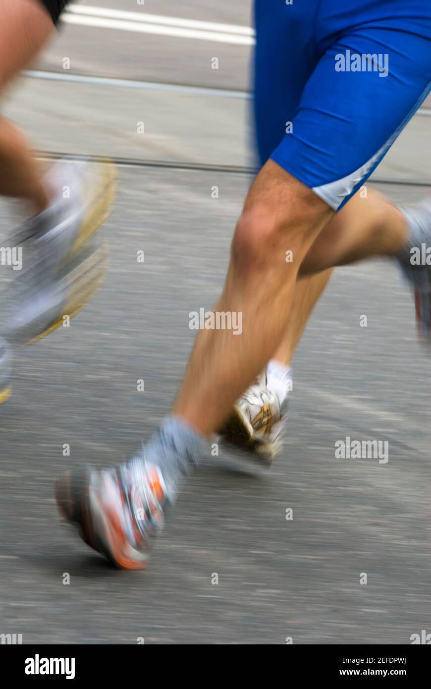 Low section view of three track runners running Stock Photo - Alamy