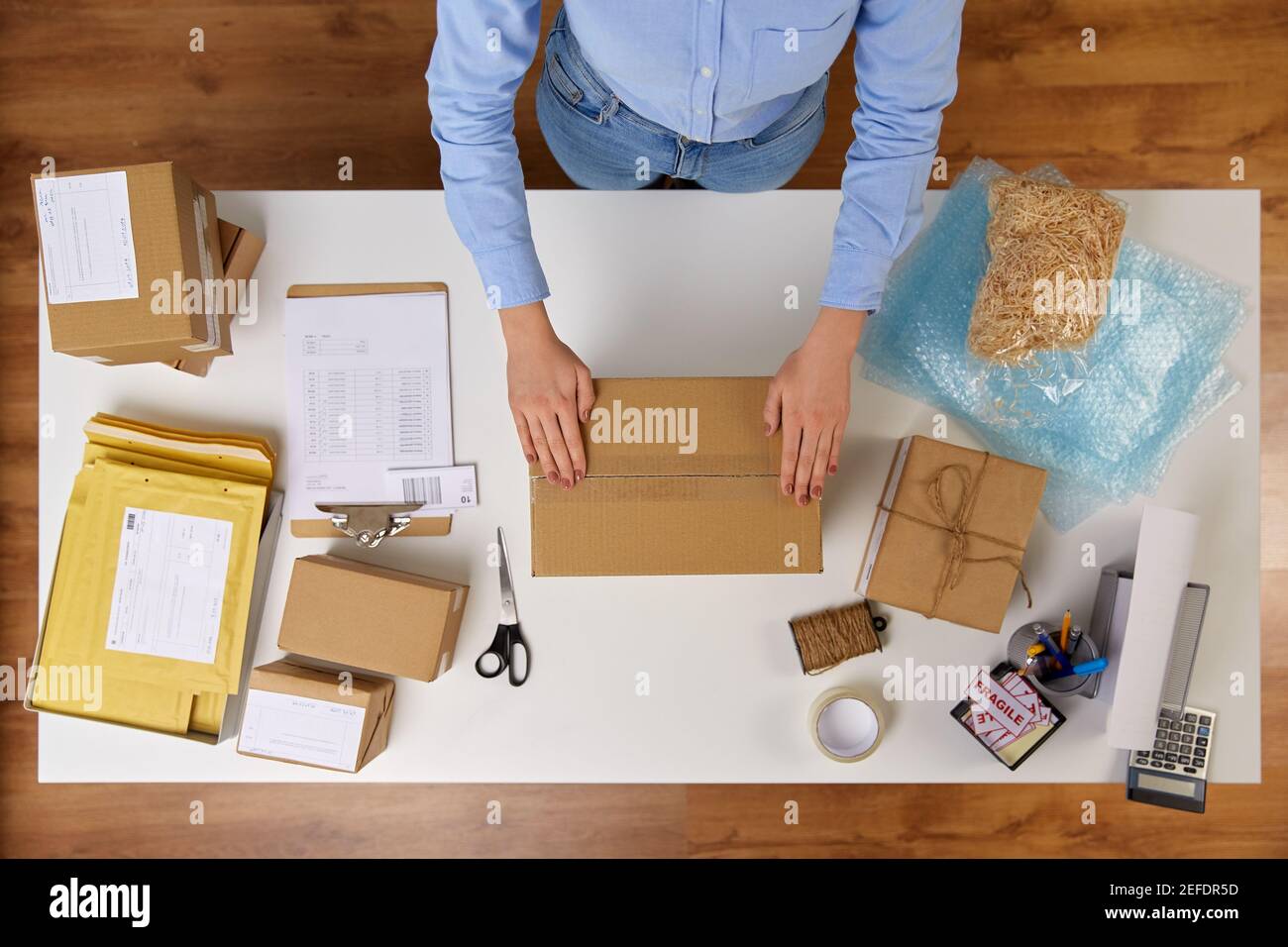 woman packing parcel box with adhesive tape Stock Photo - Alamy