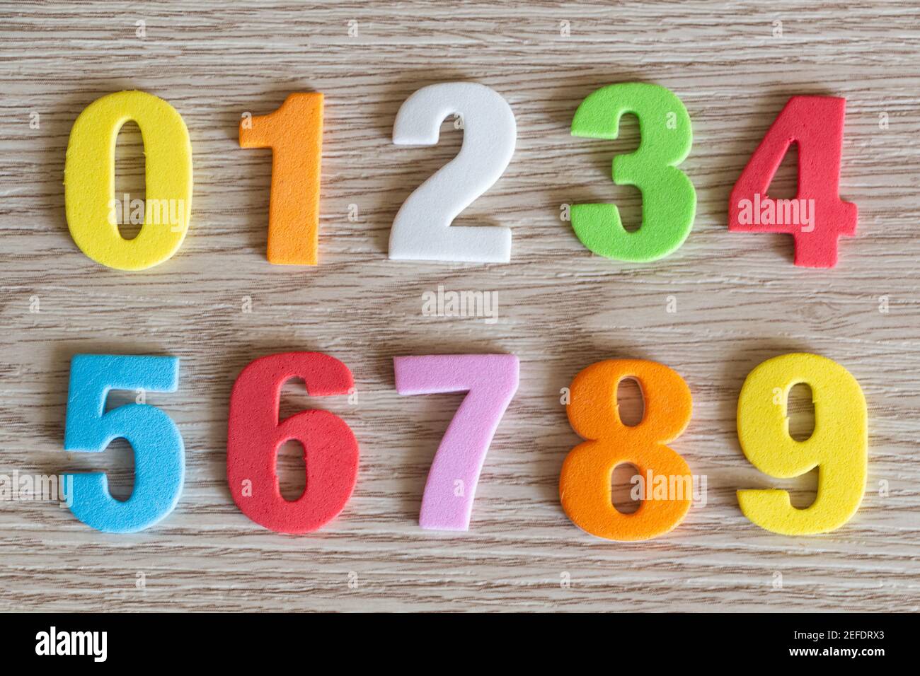 Colored numbers in foam on wooden background Stock Photo - Alamy