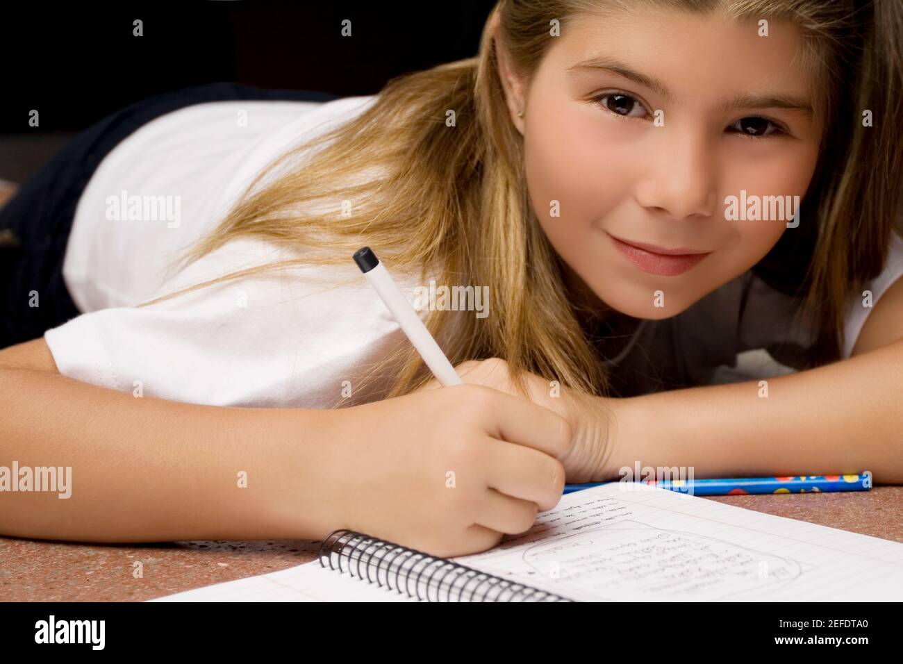 Portrait of a girl writing on a textbook with a pencil Stock Photo - Alamy