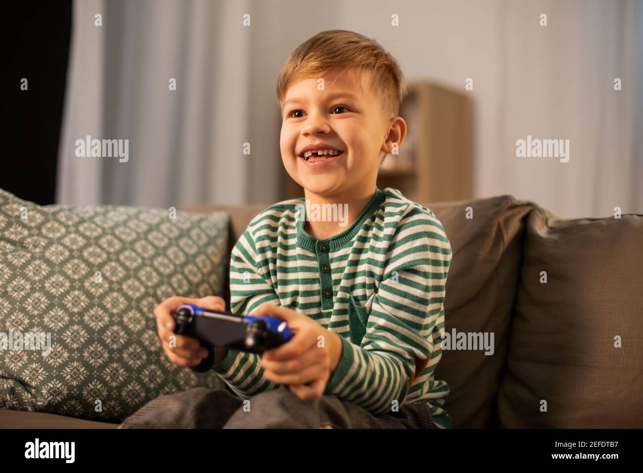 little boy with gamepad playing video game at home Stock Photo - Alamy