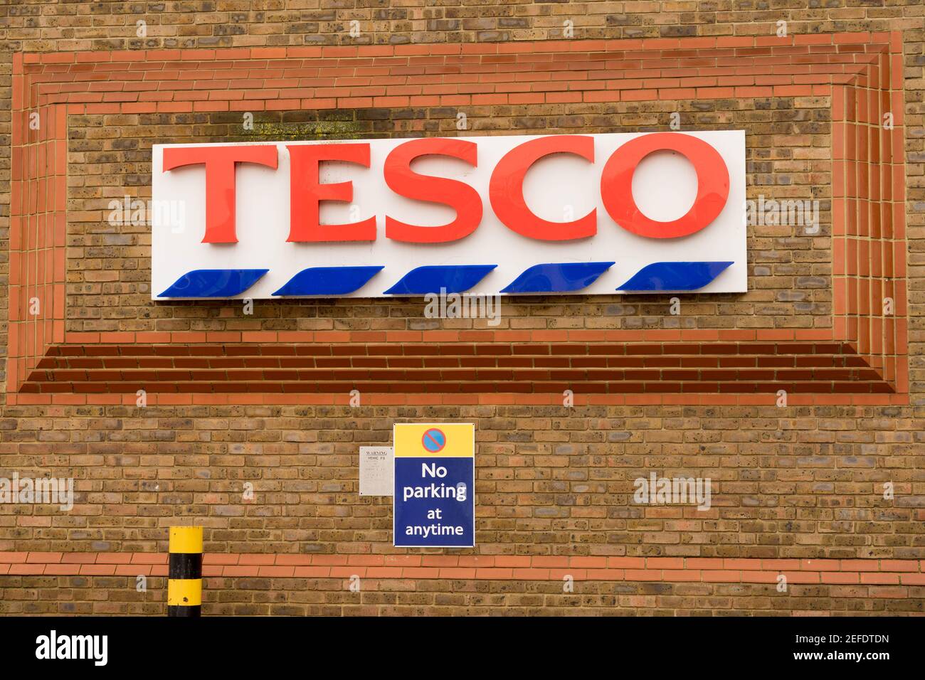 Tesco lettering engraved into red brick wall Stock Photo - Alamy