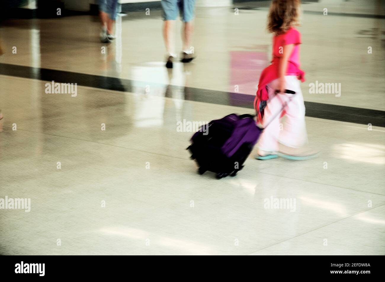 Side profile of a girl pulling a suitcase Stock Photo - Alamy