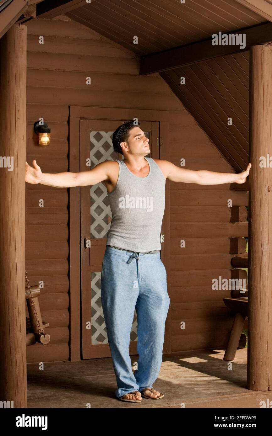 Young man standing with his arms outstretched Stock Photo - Alamy