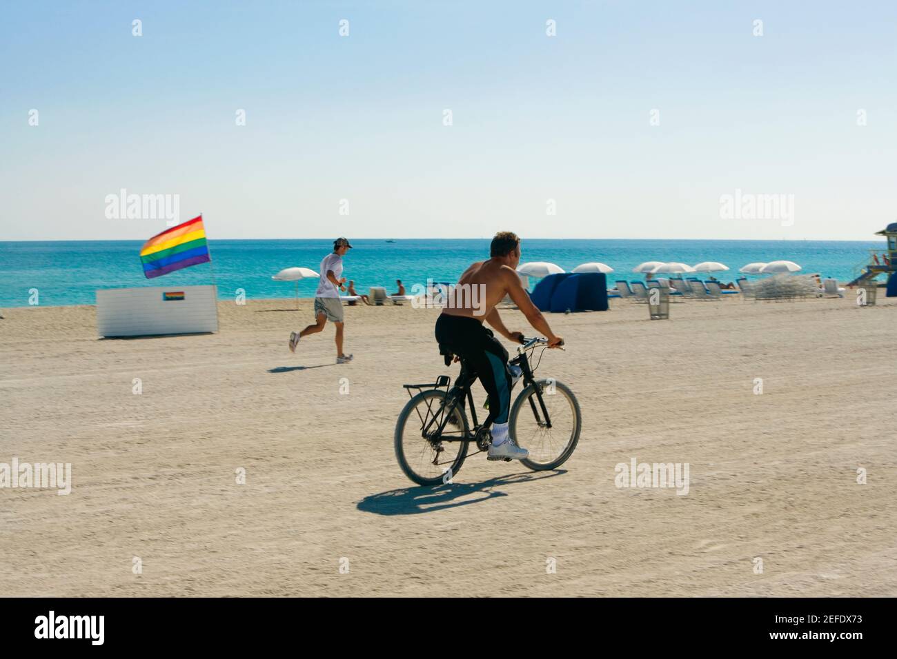 Side profile of a man cycling on the beach Stock Photo - Alamy