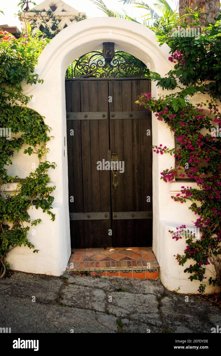 Facade of wooden doors in a stucco arch, Los Angeles, California, USA ...