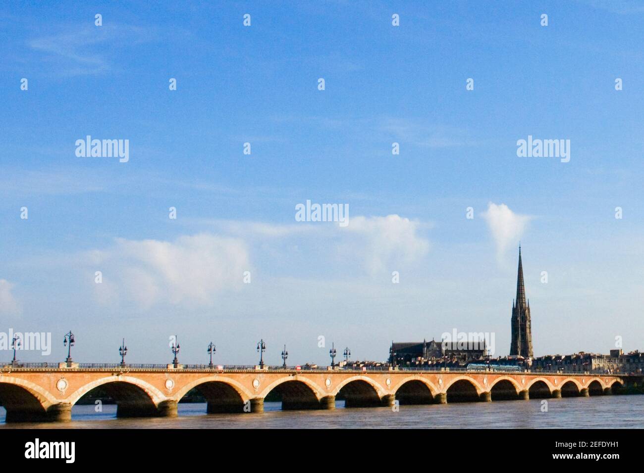 Arch bridge across a river, Pont De Pierre, St. Michel Basilica ...
