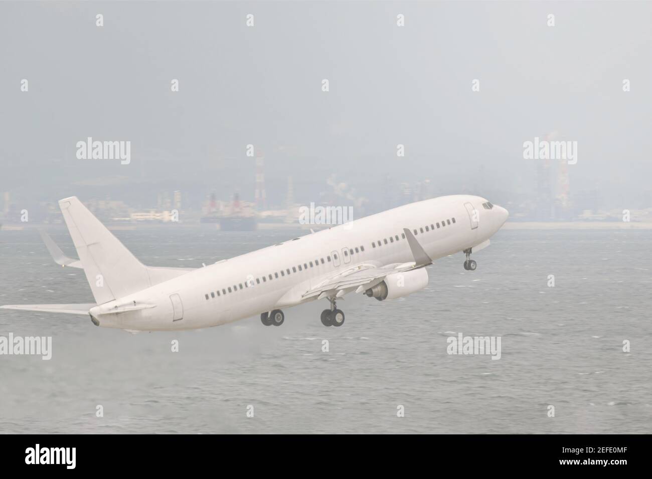white airplane taking off in haze afternoon with ocean background Stock ...