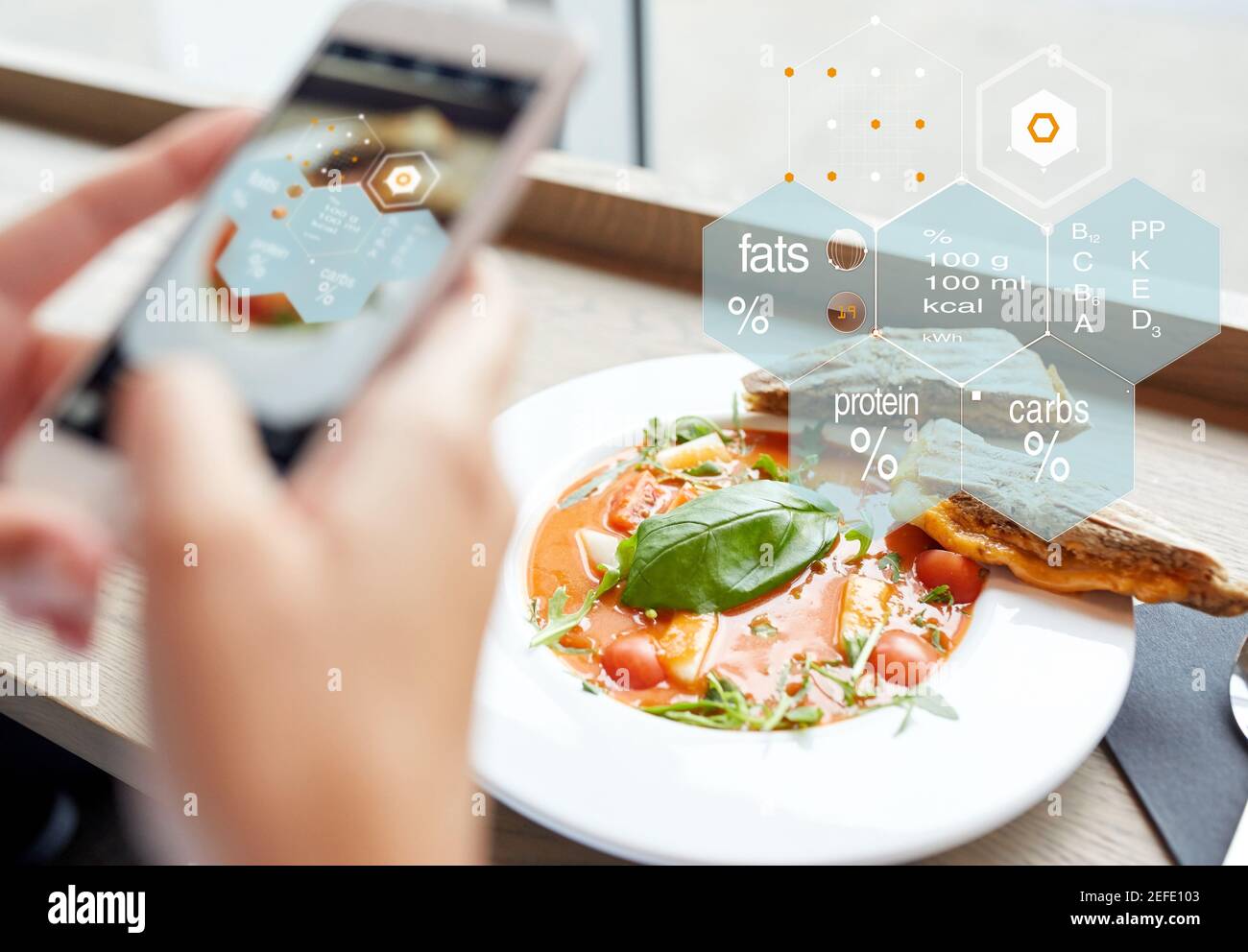 hands with phone and food nutritional value chart Stock Photo - Alamy