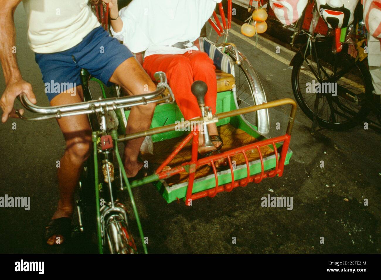 Low section view of a rickshaw driver pulling a rickshaw, Singapore ...