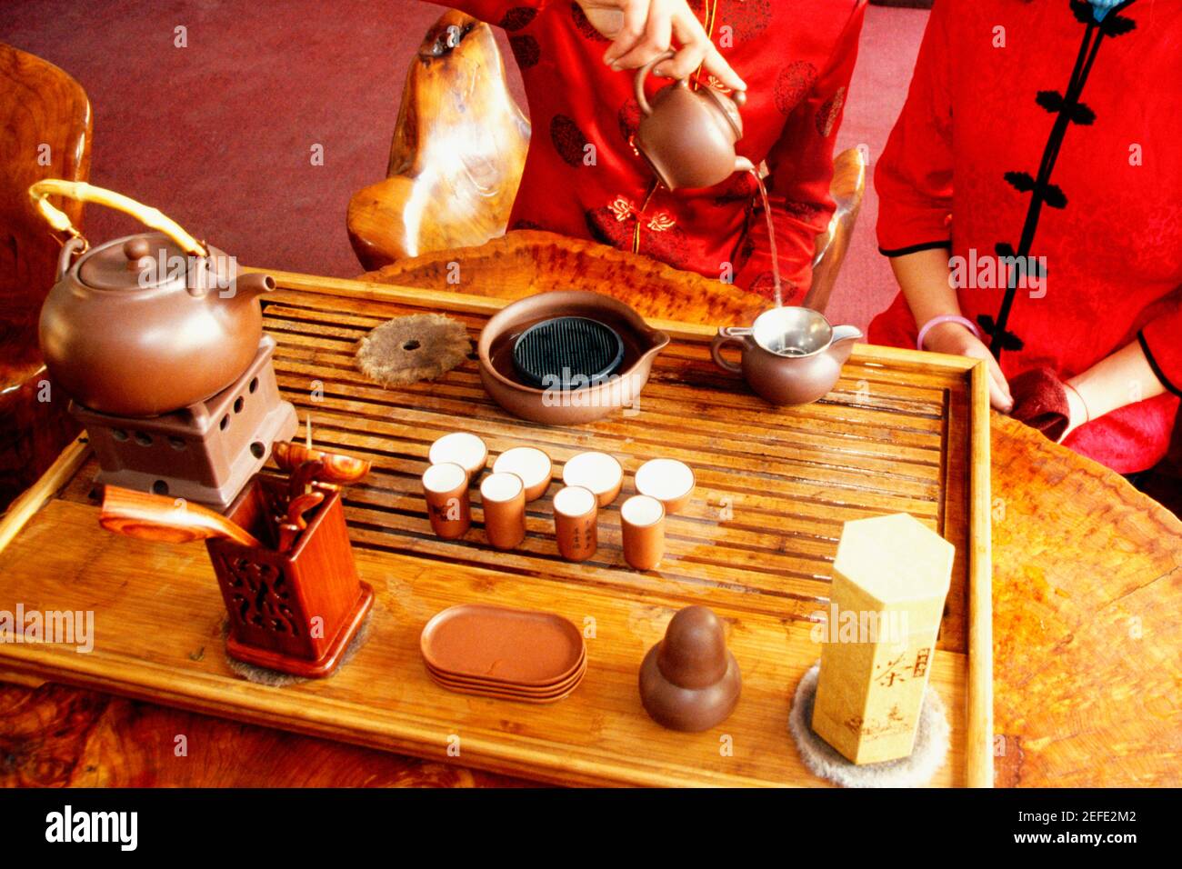 Mid section view of a woman pouring tea into a tea kettle, Tongli ...