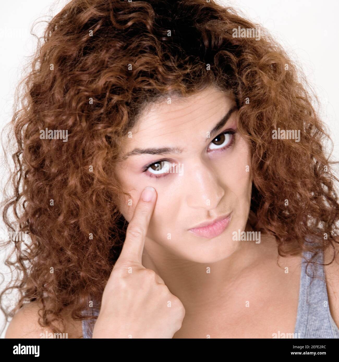 Portrait of a young woman pointing at her eye Stock Photo - Alamy