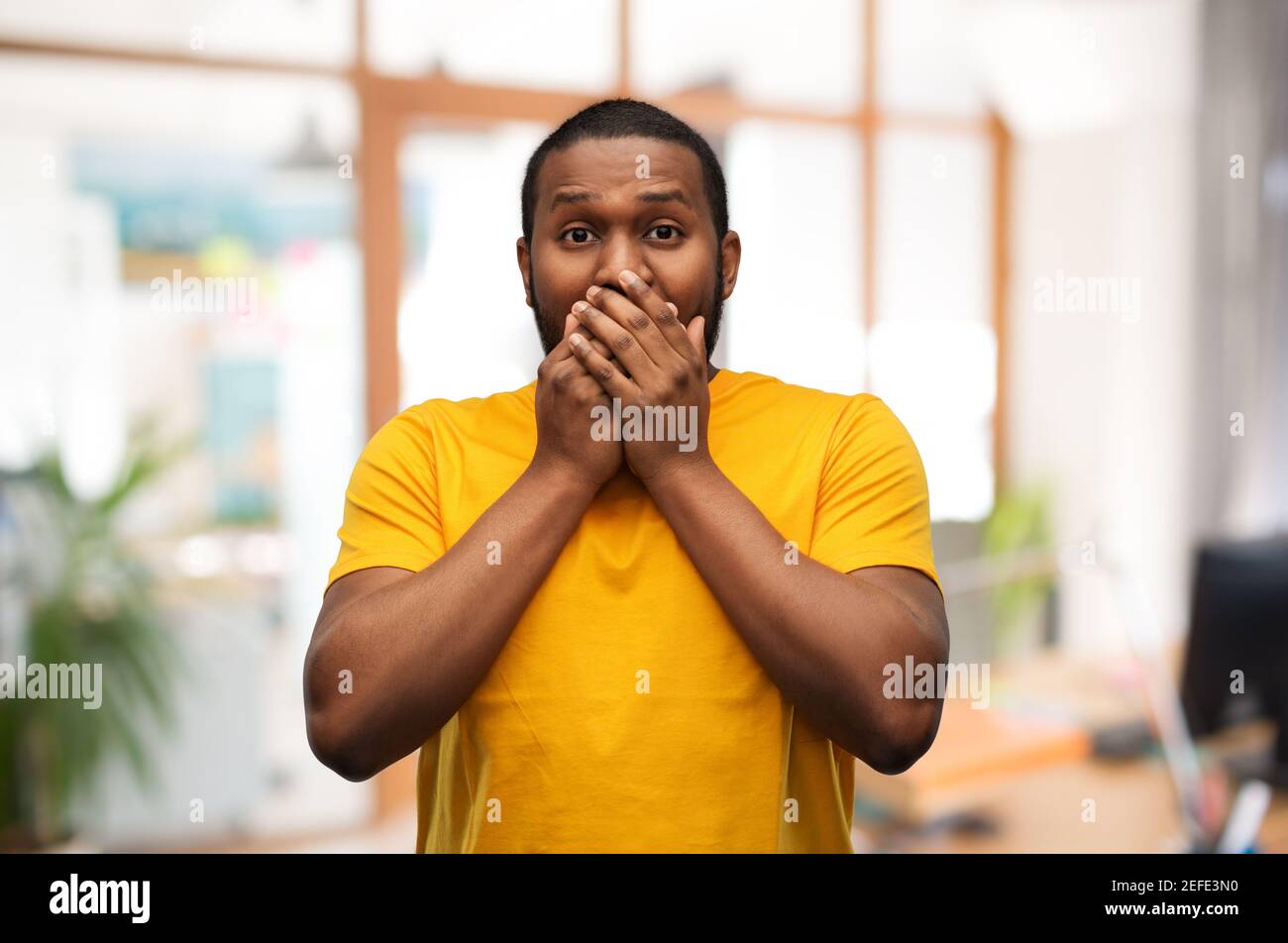 scared african american man covering his mouth Stock Photo - Alamy