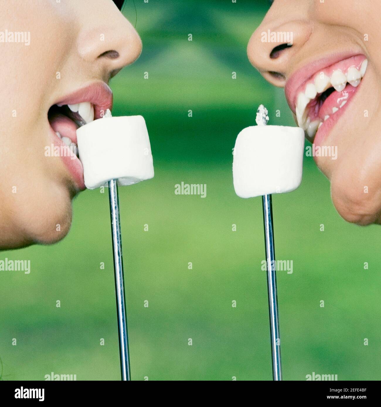 Close-up of two young women eating marshmallows Stock Photo - Alamy