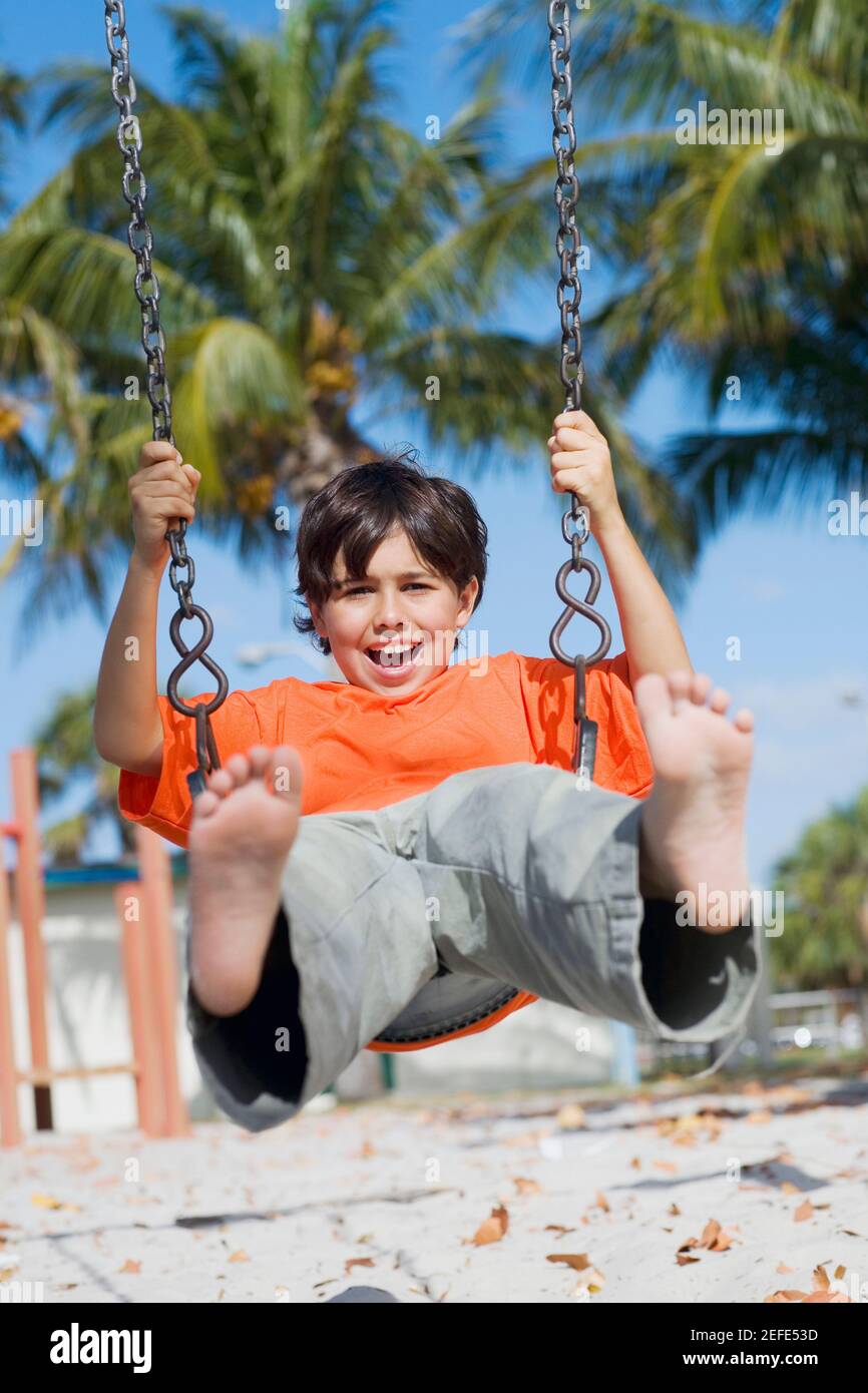 Boy swinging on a swing Stock Photo - Alamy