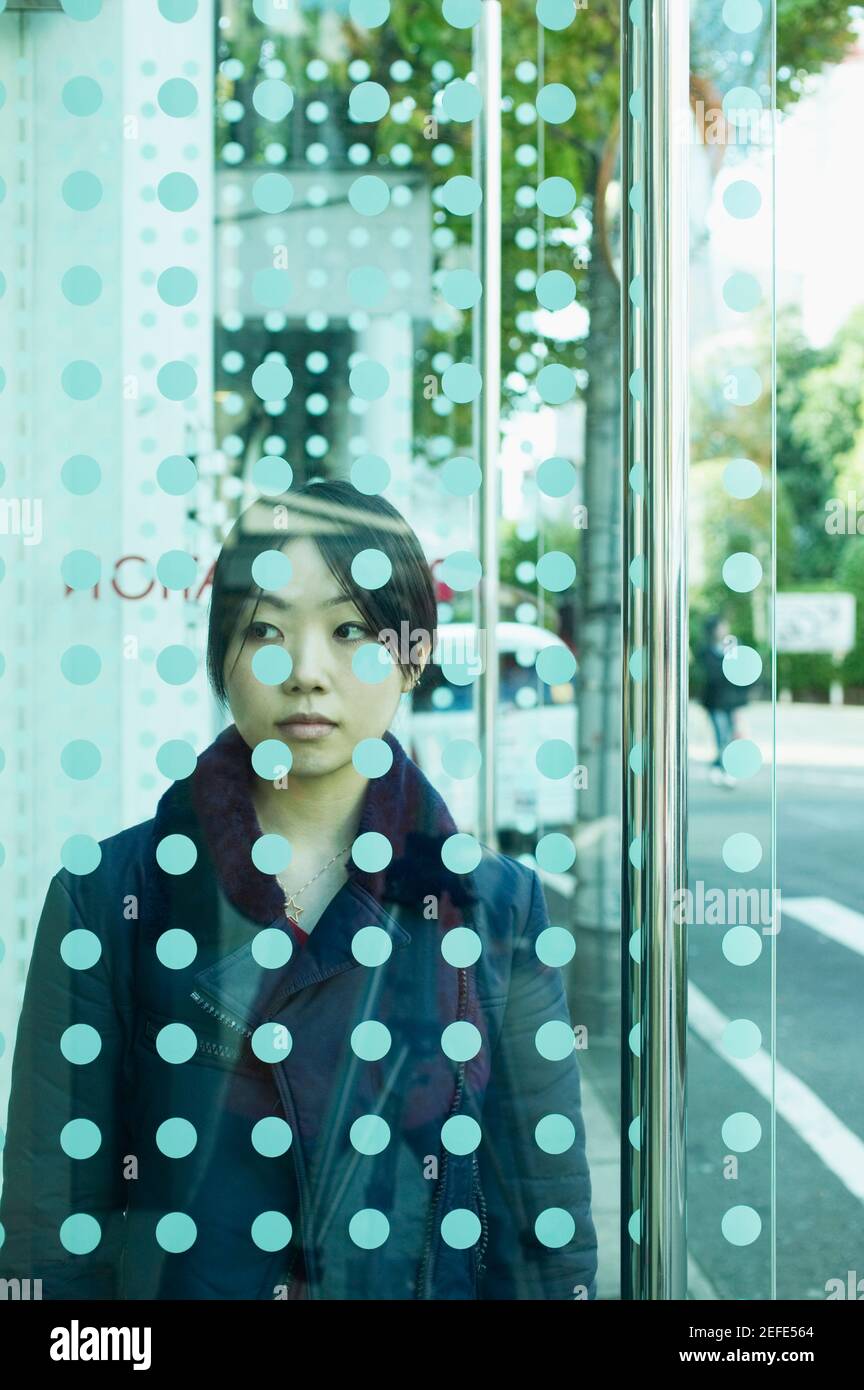 Young woman standing behind a glass door Stock Photo - Alamy