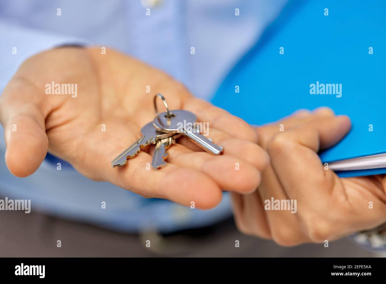 close up of male hands holding keys and folder Stock Photo - Alamy