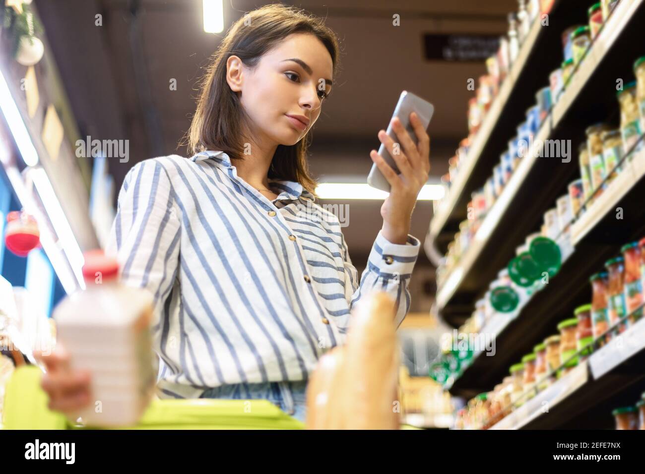 Modern Shopping. Young Lady Using Phone Buying Food Groceries Standing ...