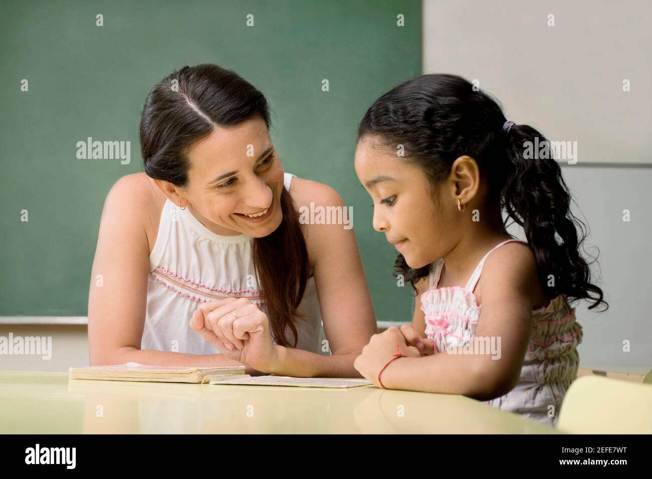Female teacher teaching her student in a classroom Stock Photo - Alamy
