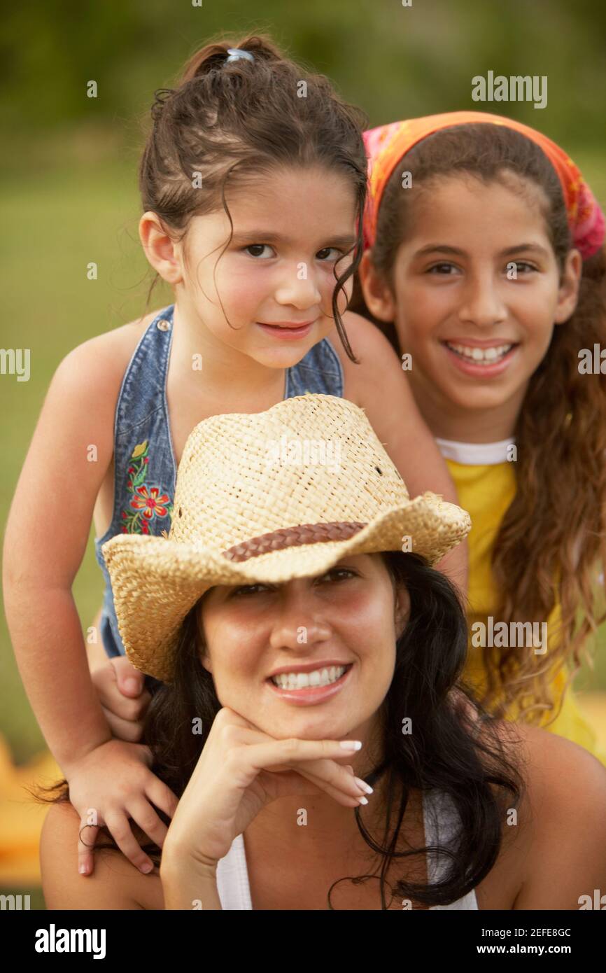 Portrait of a young woman posing with her two daughters with her hand ...