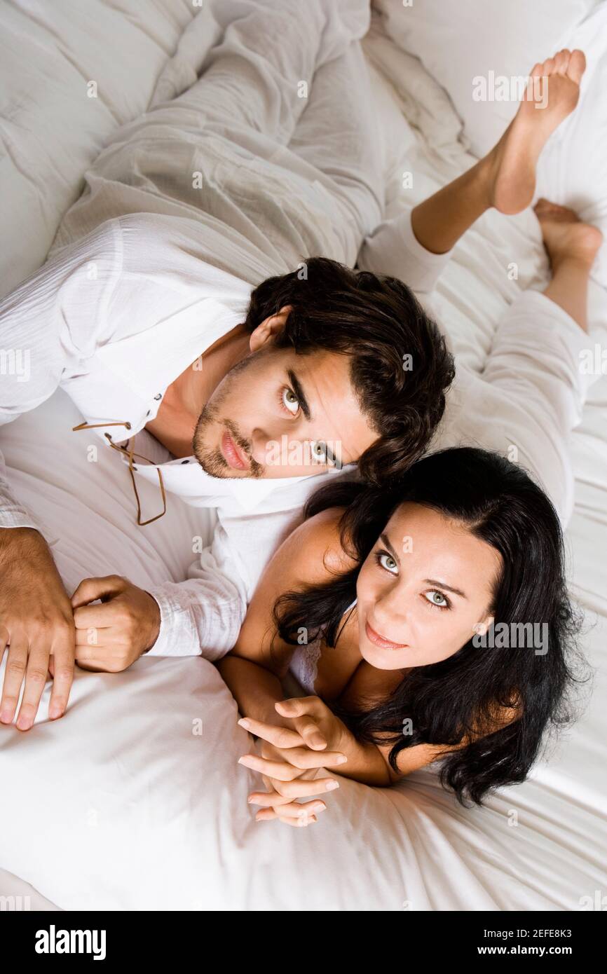 Portrait of a young couple lying on the bed Stock Photo - Alamy