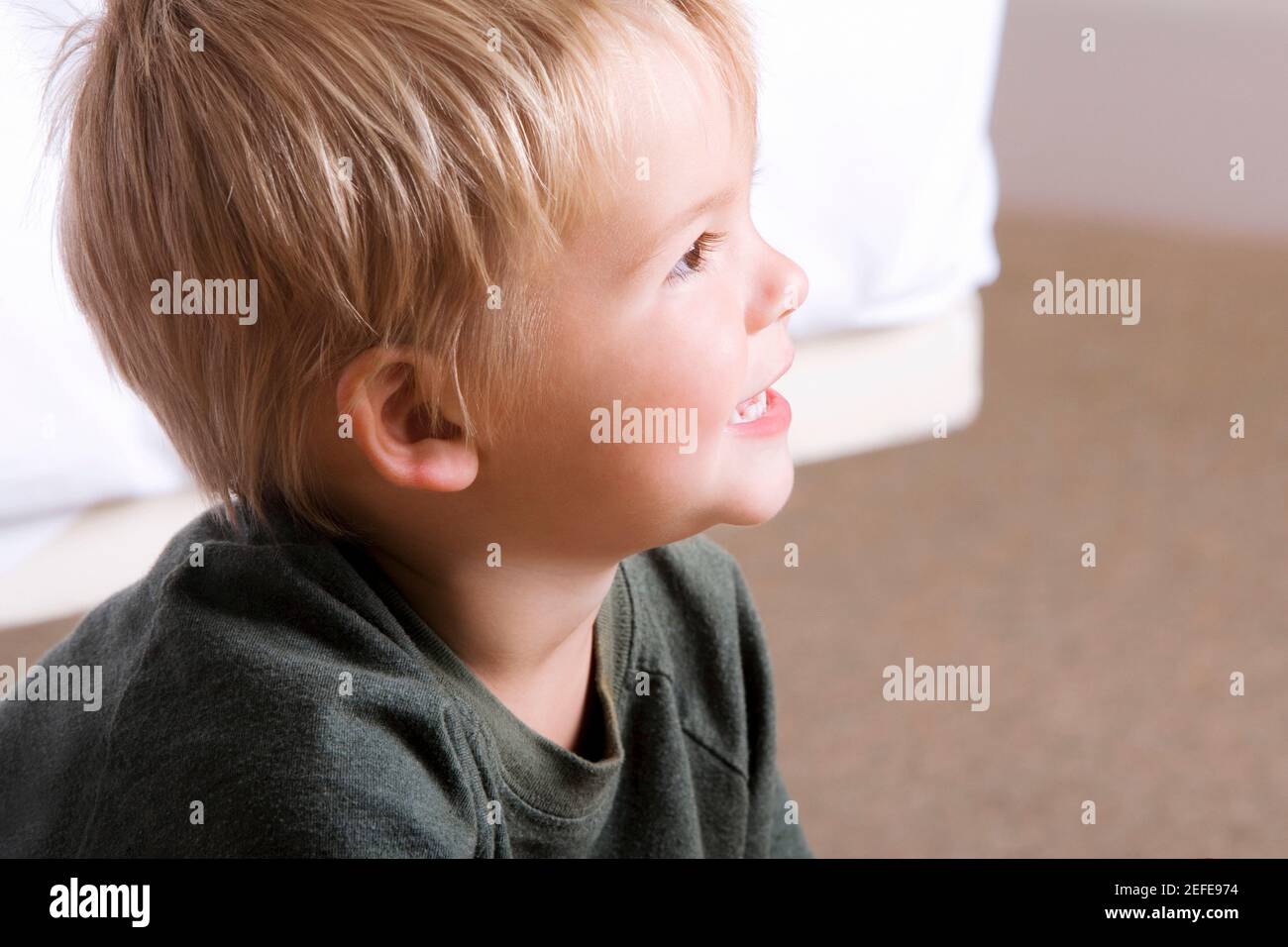 Side profile of a boy sitting on the floor Stock Photo - Alamy