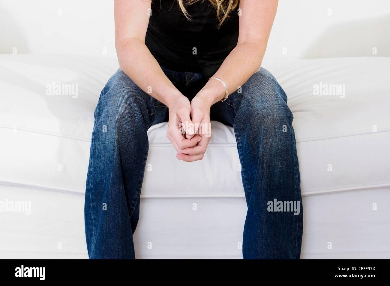 Mid section view of a young woman sitting on the bed Stock Photo - Alamy