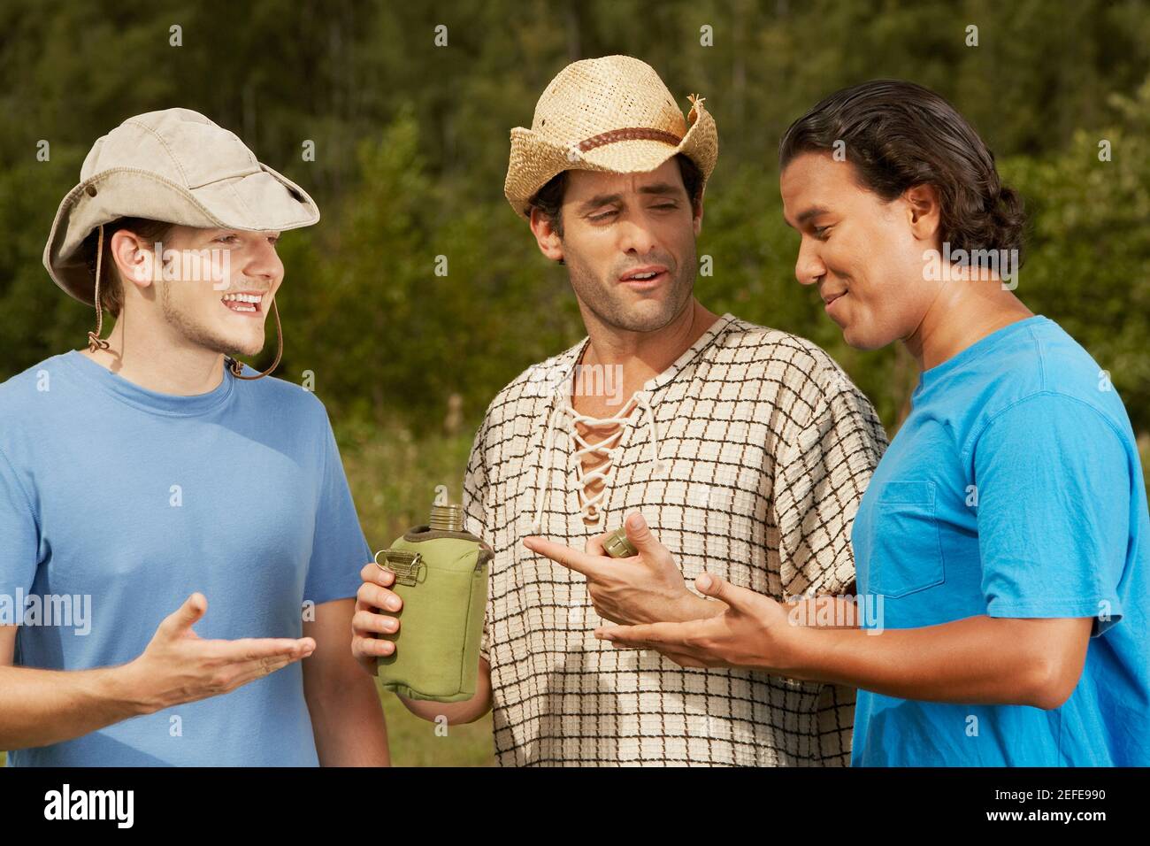 Mid adult man standing with two young men Stock Photo - Alamy
