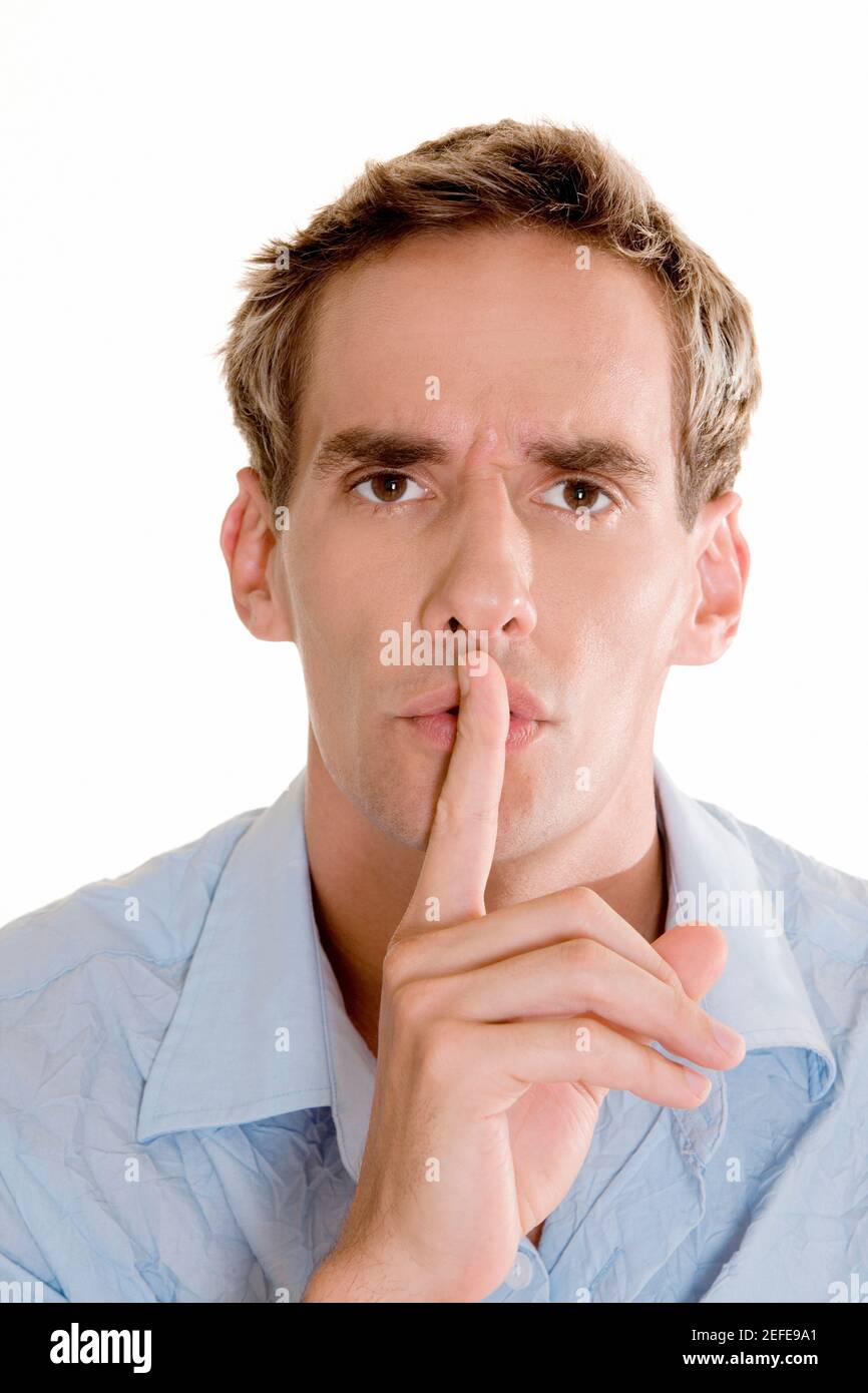 Portrait of a young man with a finger on his lip Stock Photo - Alamy