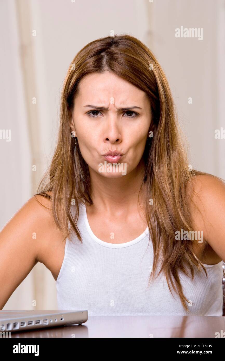 Portrait of a young woman puckering her lips Stock Photo - Alamy