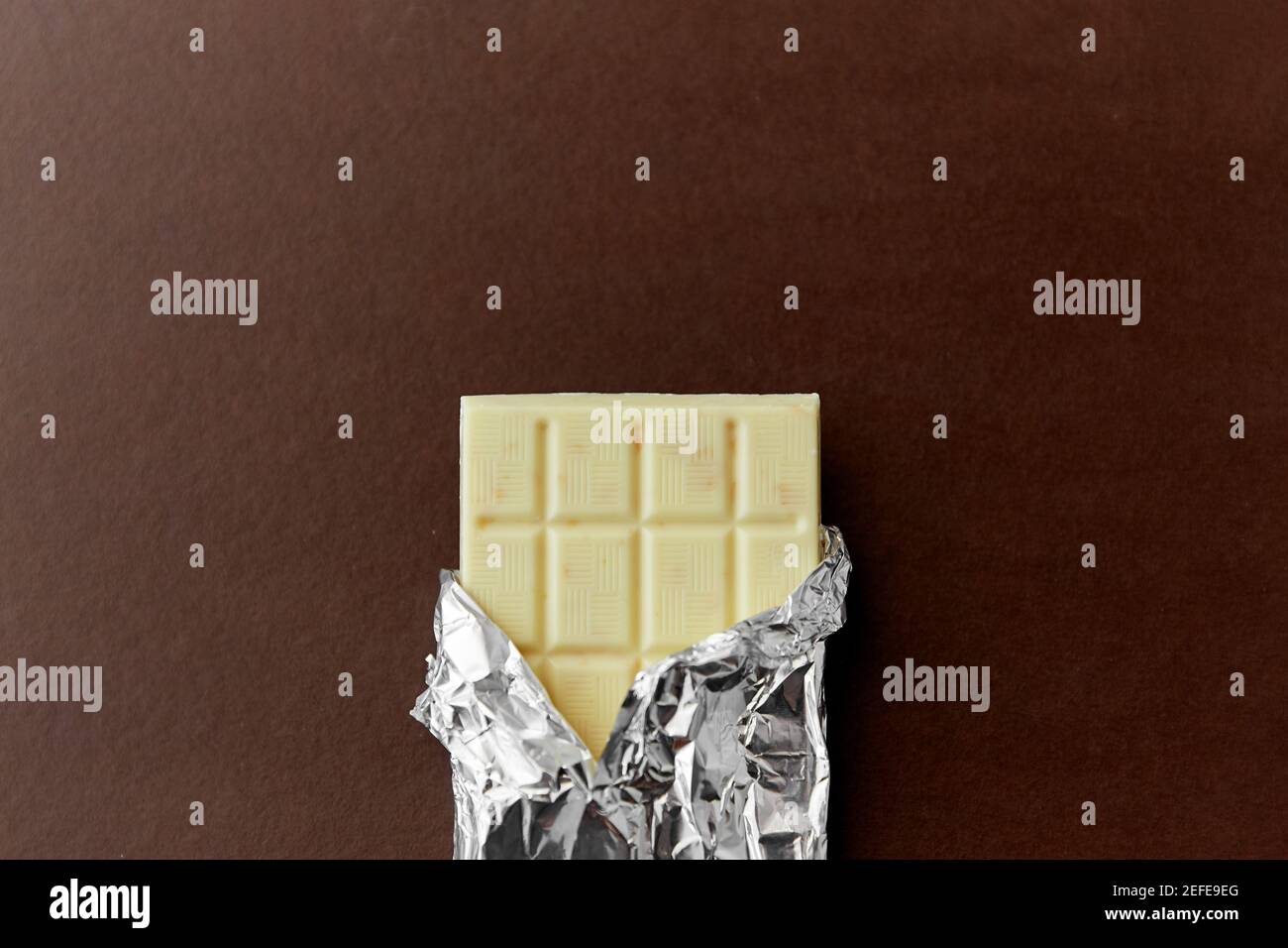 white chocolate bar in foil wrapper on brown Stock Photo - Alamy