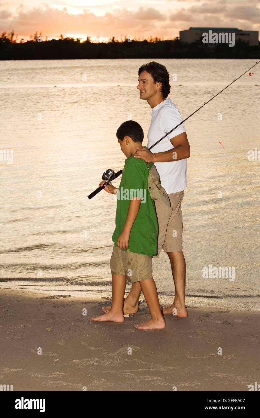 Side profile of a father and his son fishing hi-res stock photography ...
